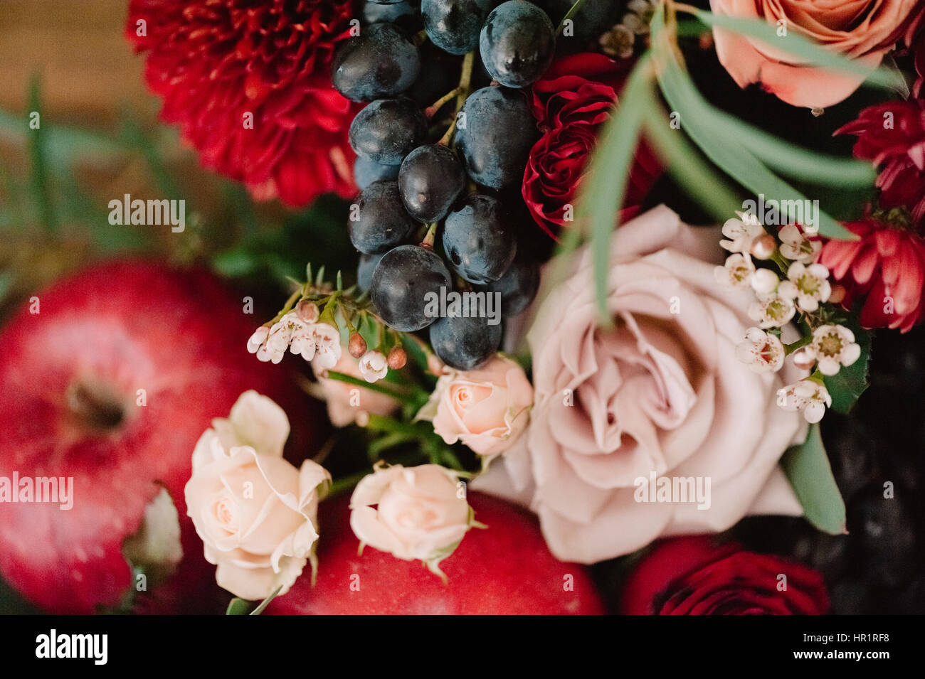 Autumnal wedding composition of roses, apples, grape and pomergranate ...
