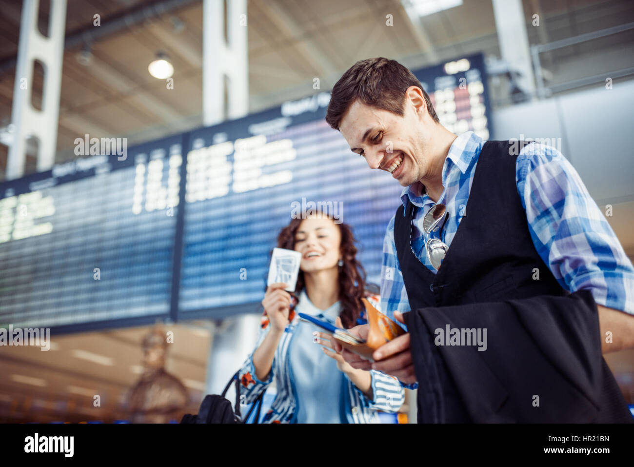 Welcoming embrace. Young loving couple hugging in the airport terminal ...