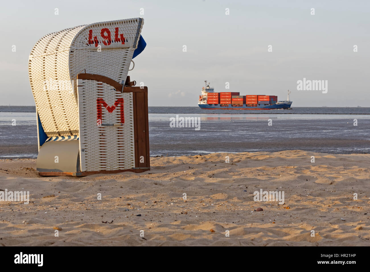 Container ship in the Wadden Sea, roofed wicker beach chair Stock Photo ...
