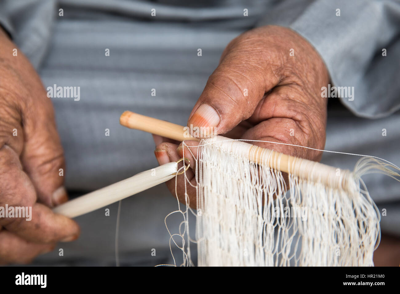 Muscat, Oman - Feb 4, 2017: An Omani man weaving a traditional fishing ...