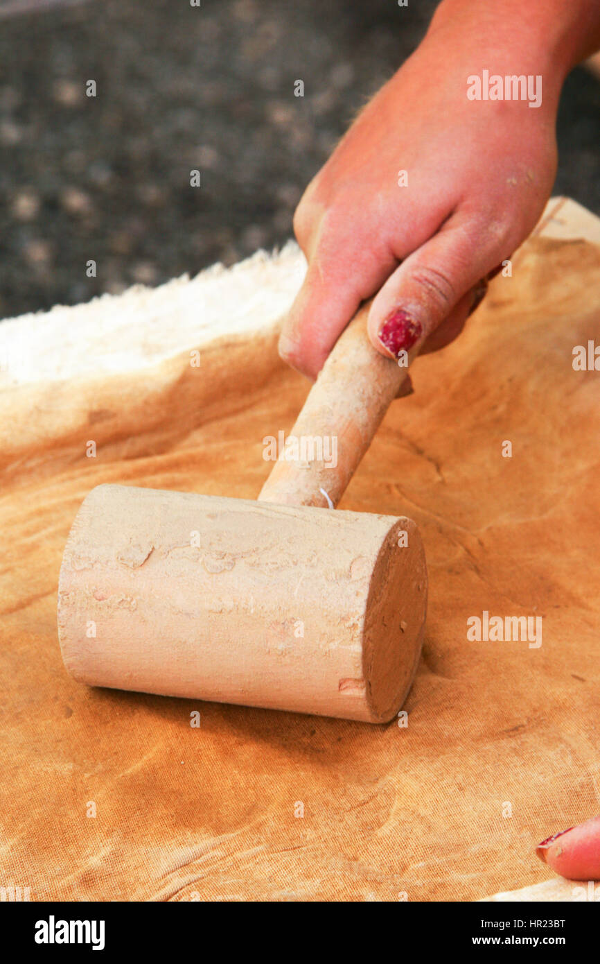 Female hand holding wooden mallet Stock Photo - Alamy