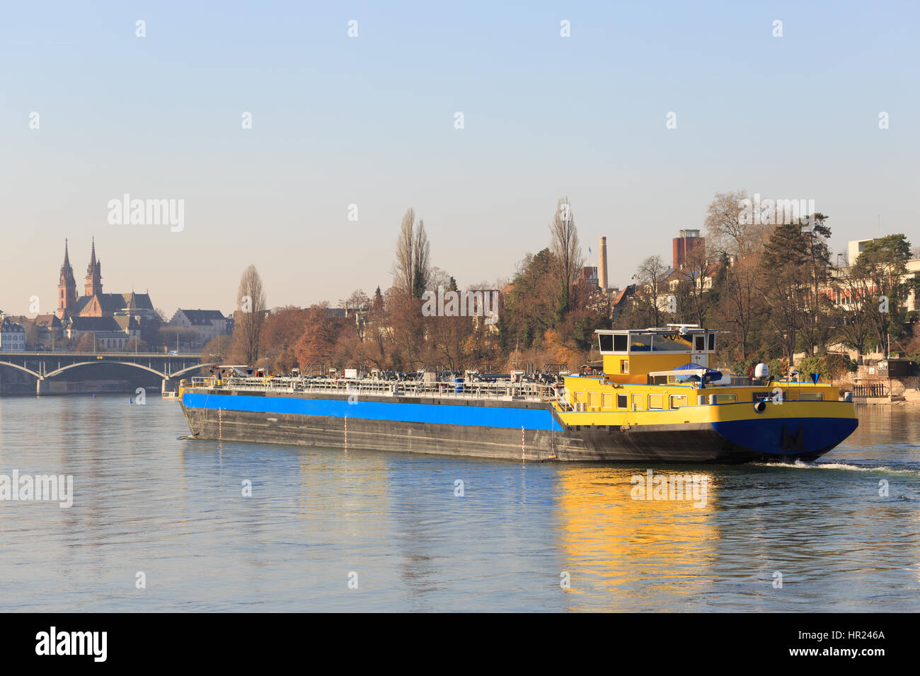 An anonymous cargo ship in front of the Basel Cathedral on the Rhine in ...