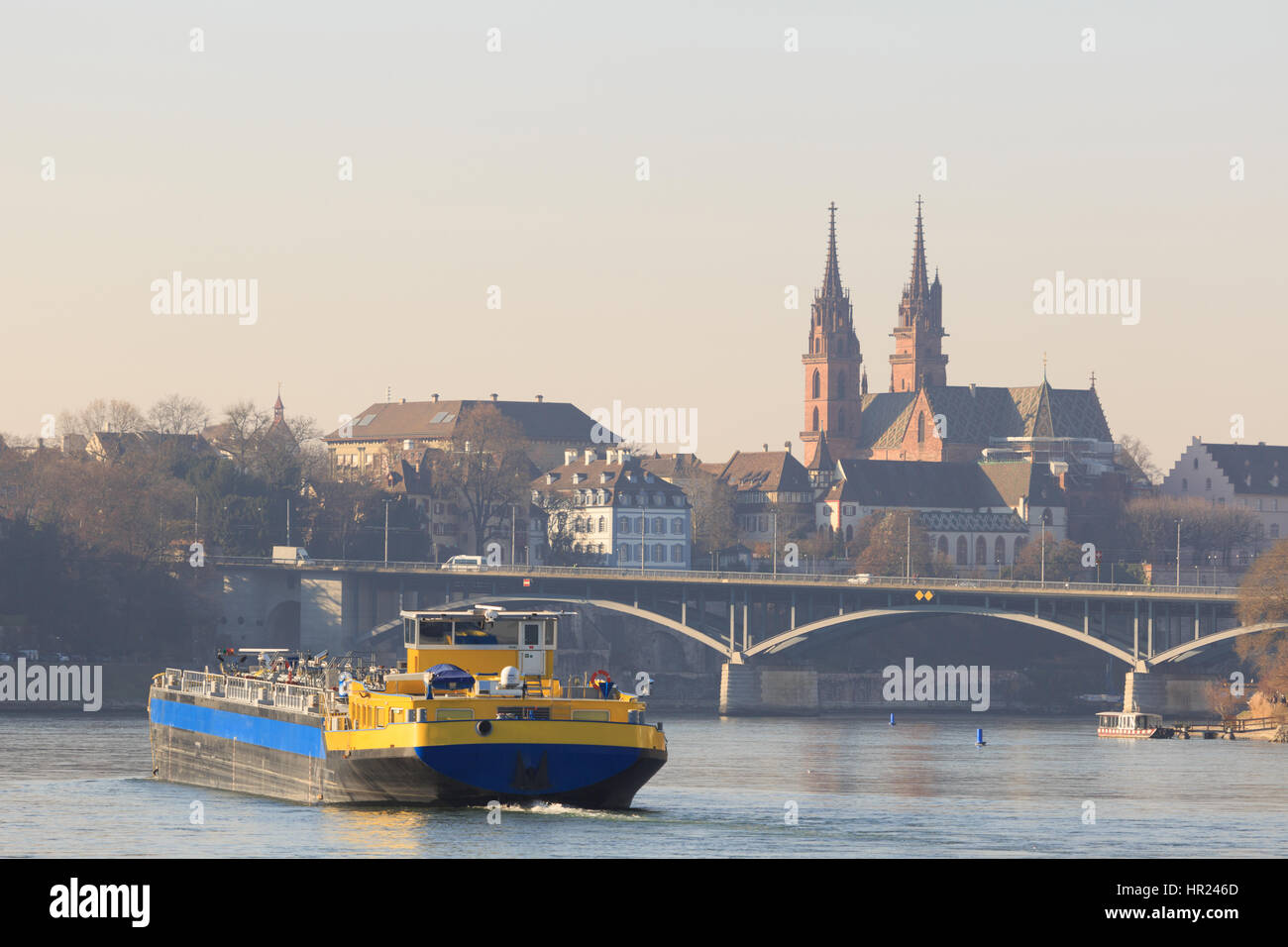An anonymous cargo ship in front of the Basel Cathedral on the Rhine in ...