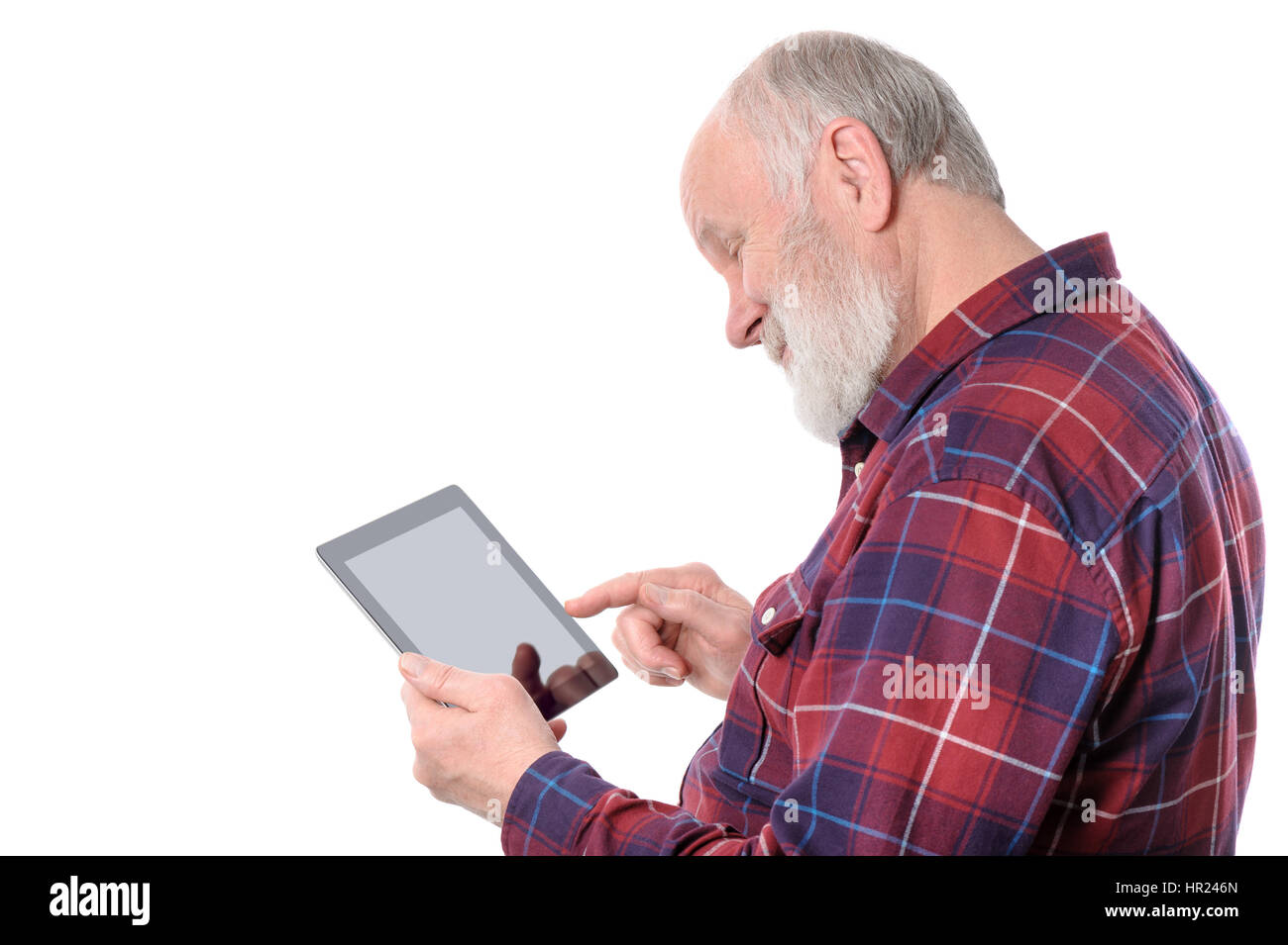 Senior man smiling while doing with something at screen of tablet ...