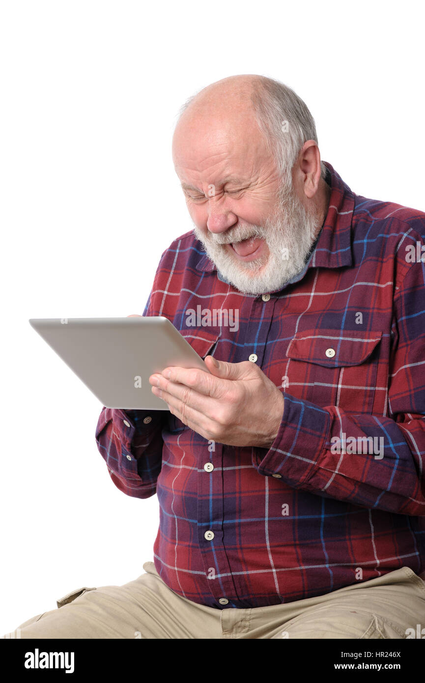 Senior man laughing with something at screen of tablet computer ...