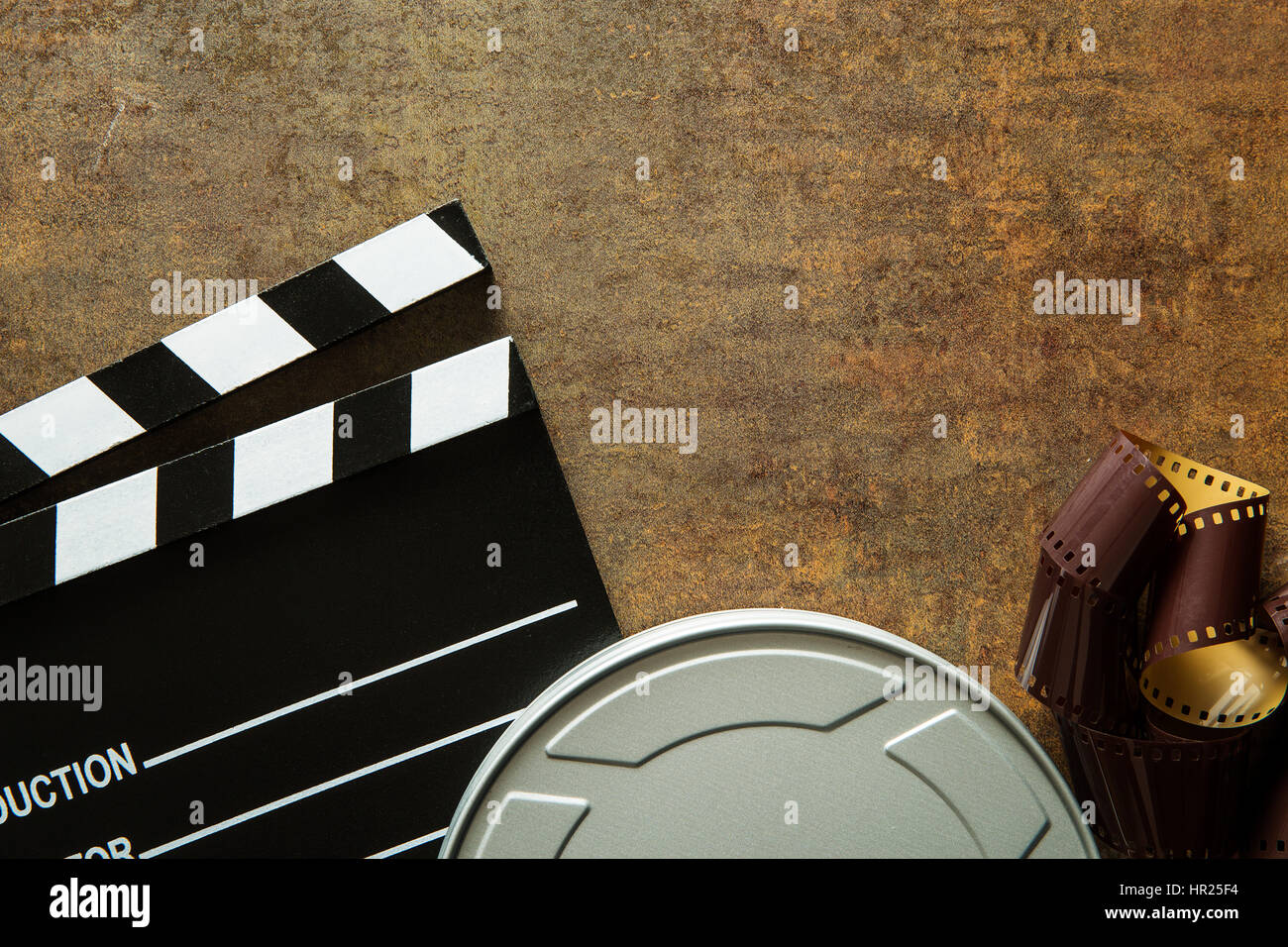 Clapper board with film reel on rusty background. Top view Stock Photo ...