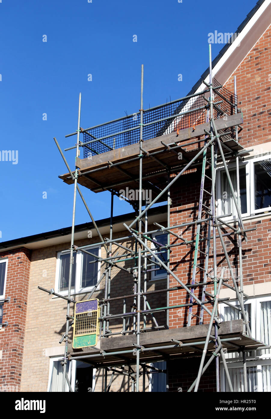 Scaffolding on exterior of modern building with blue sky background ...