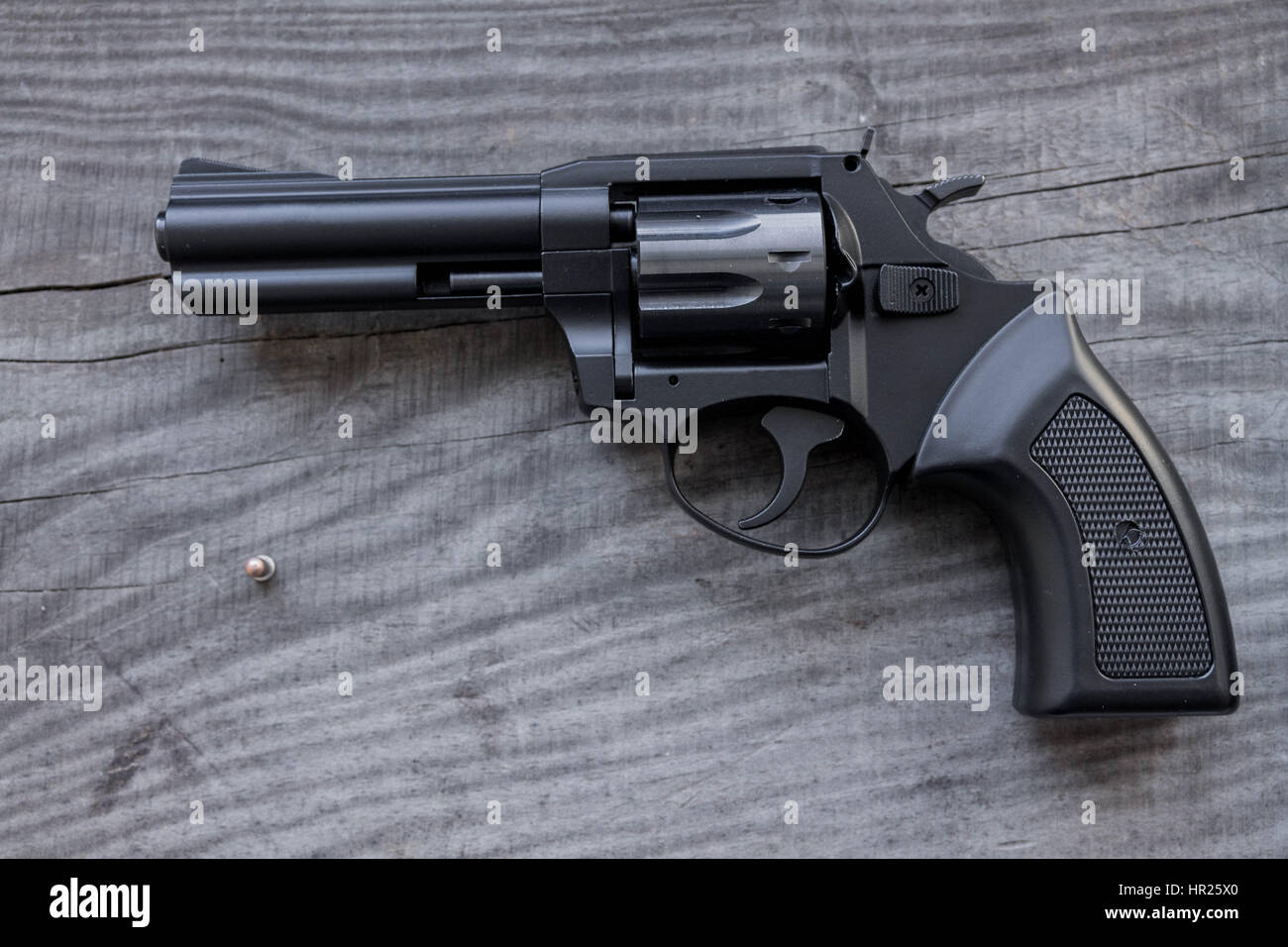 Black revolver with a drum on a wooden background Stock Photo - Alamy