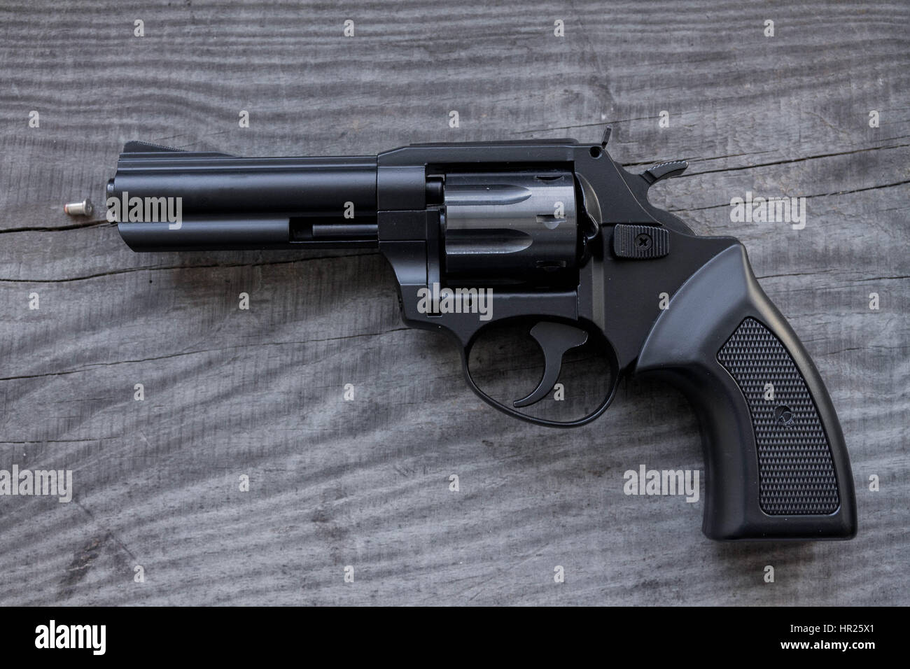 Black revolver with a drum on a wooden background Stock Photo - Alamy
