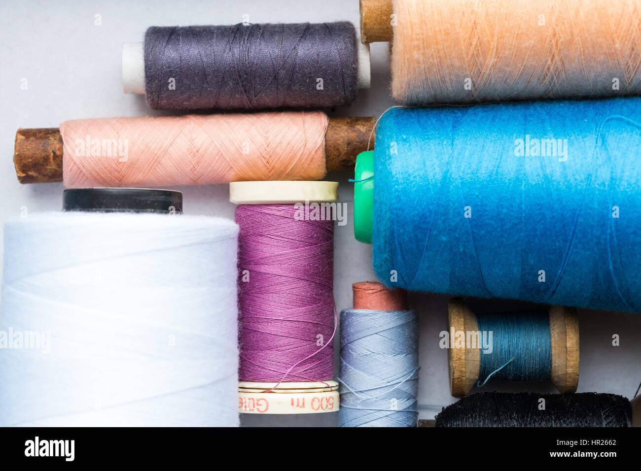 different sizes of the color bobbin of thread lying on a white ...