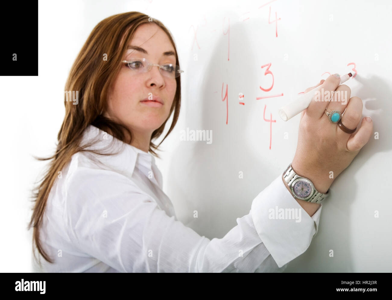 female teacher writing on a blackboard during a maths lesson - over a ...