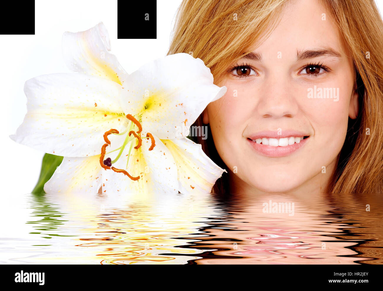 healthy girl smiling portrait holding a lily flower next to her face ...