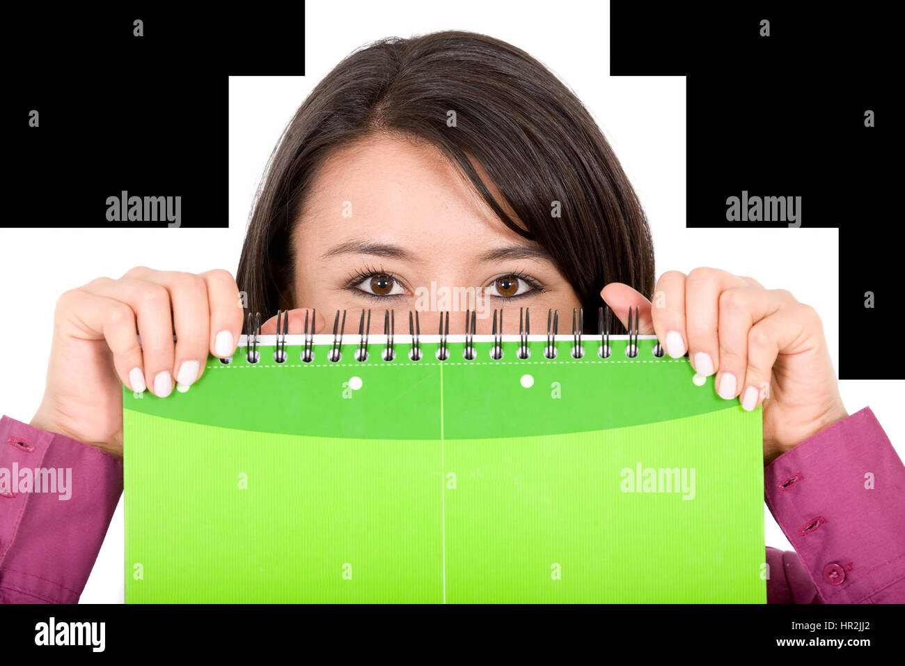 female college student peeping over a green notebook isolated over a ...