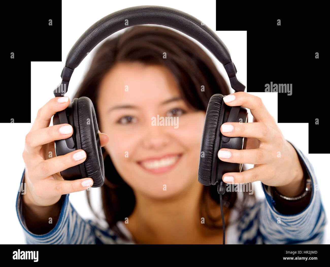 girl holding headphones and smiling isolated over a white background ...