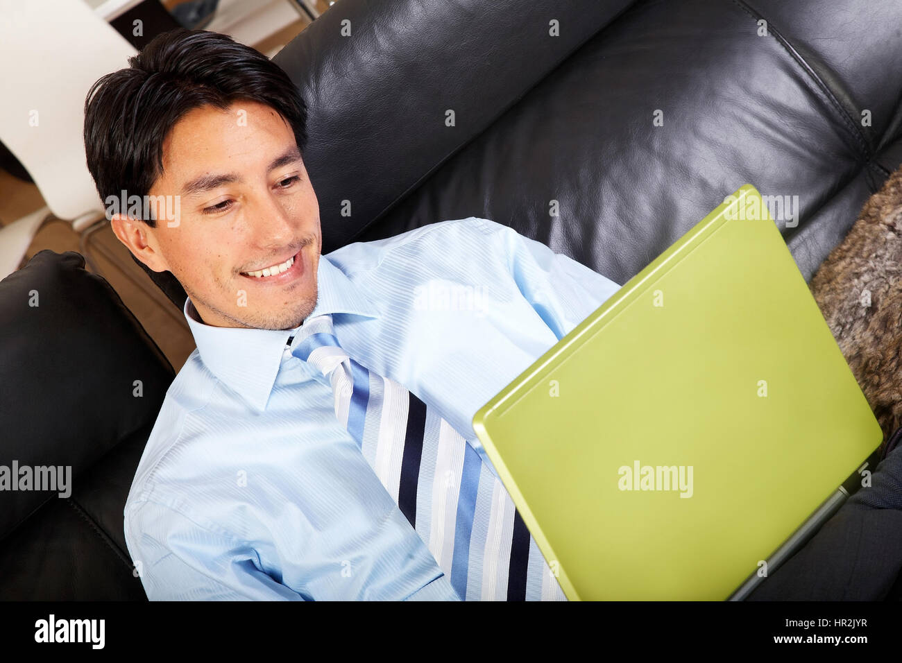 business man on a laptop computer browsing the internet at home ...