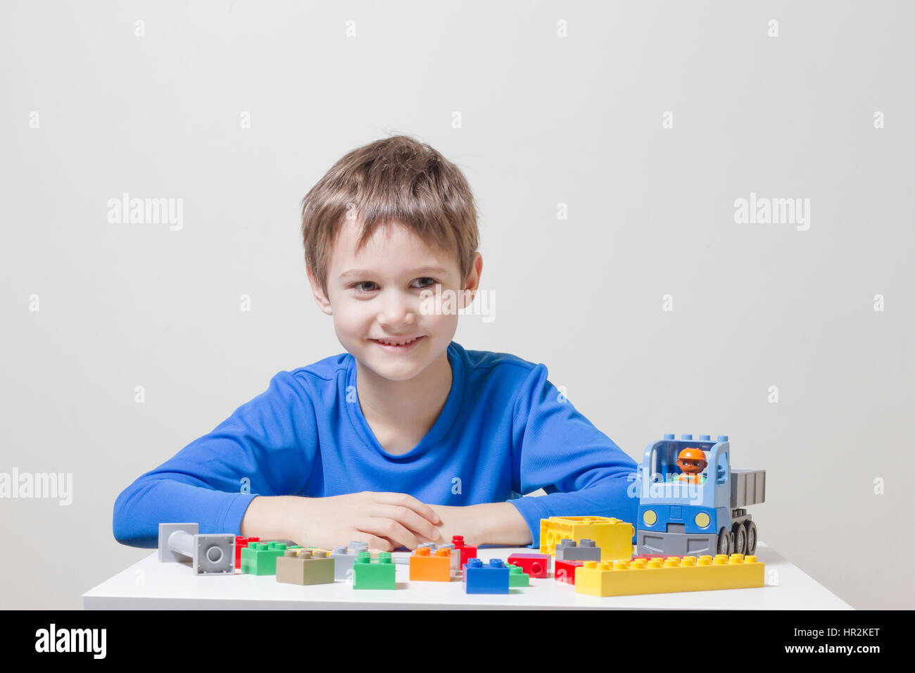 Little kid boy playing with colorful plastic construction bricks at ...