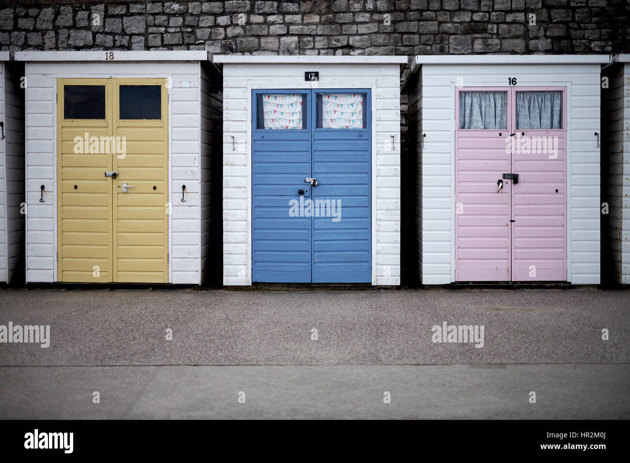 Three white beach huts with coloured doors on the sea front Stock Photo ...