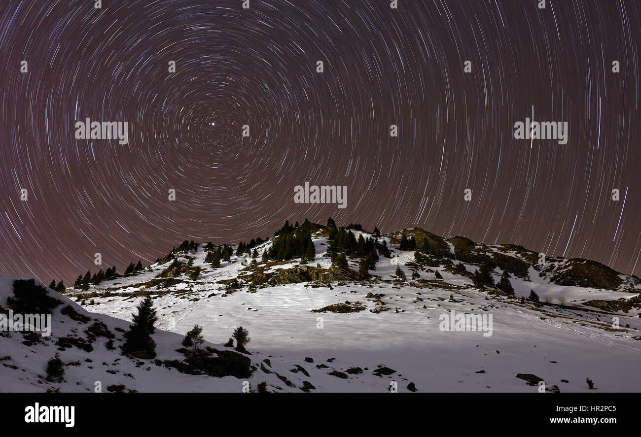 Long exposure landscape with the Polaris star and mountains with snow ...