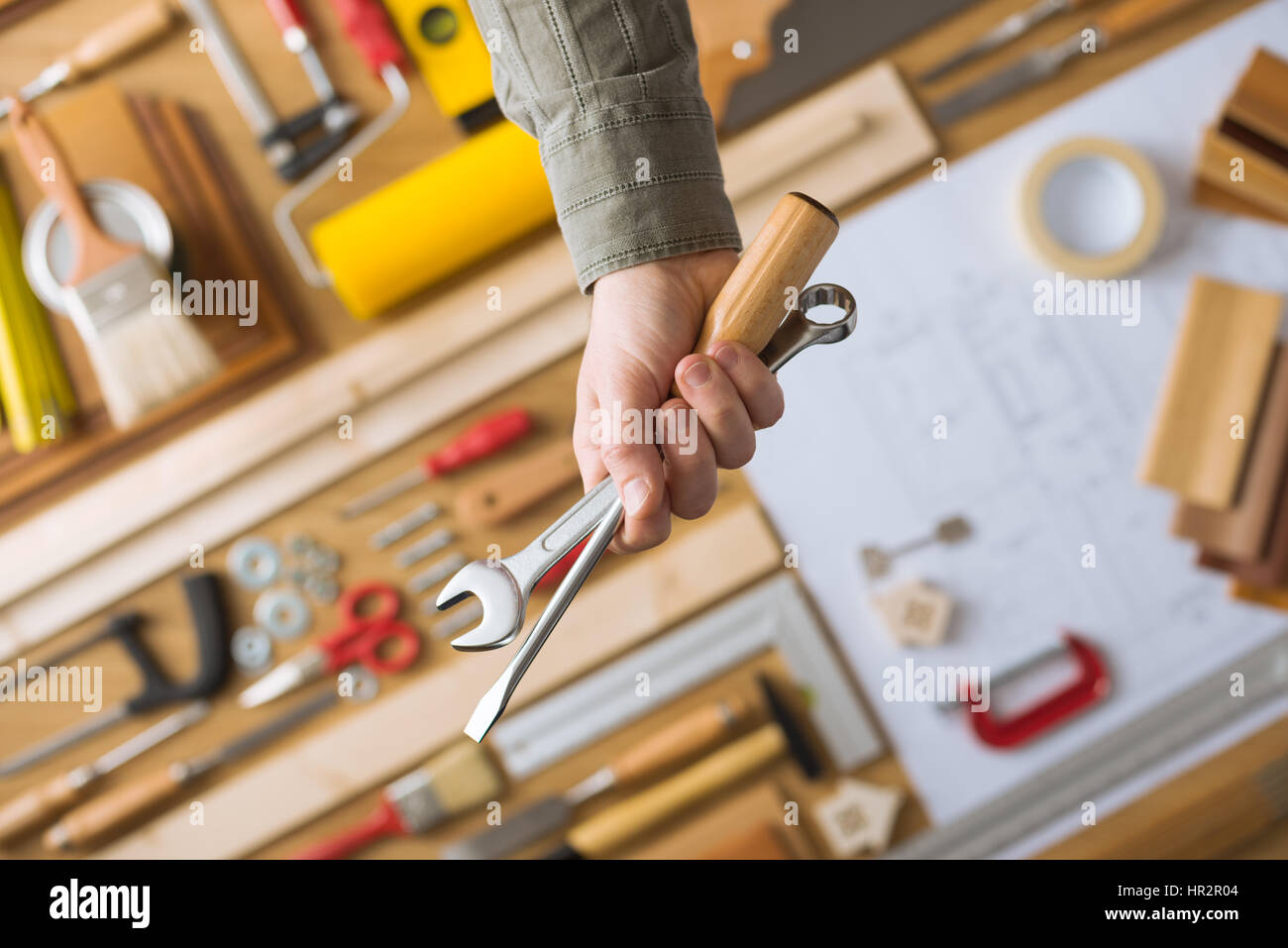 Male hand holding construction work tools, work table with build and ...