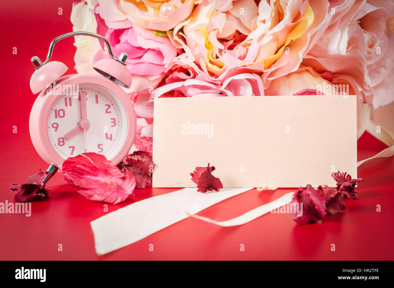 Blank card and Pink alarm clock with bouquet pink rose on red ...