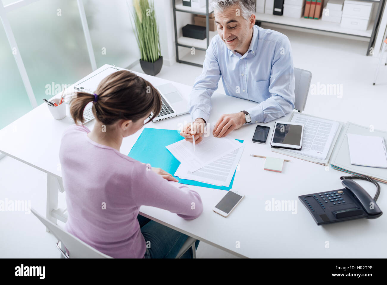 Confident advisor meeting with a customer in his office, he is ...