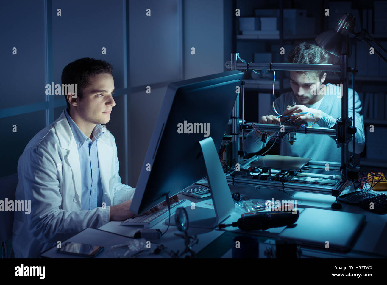 Engineering team working in the lab at night, a student is working with ...