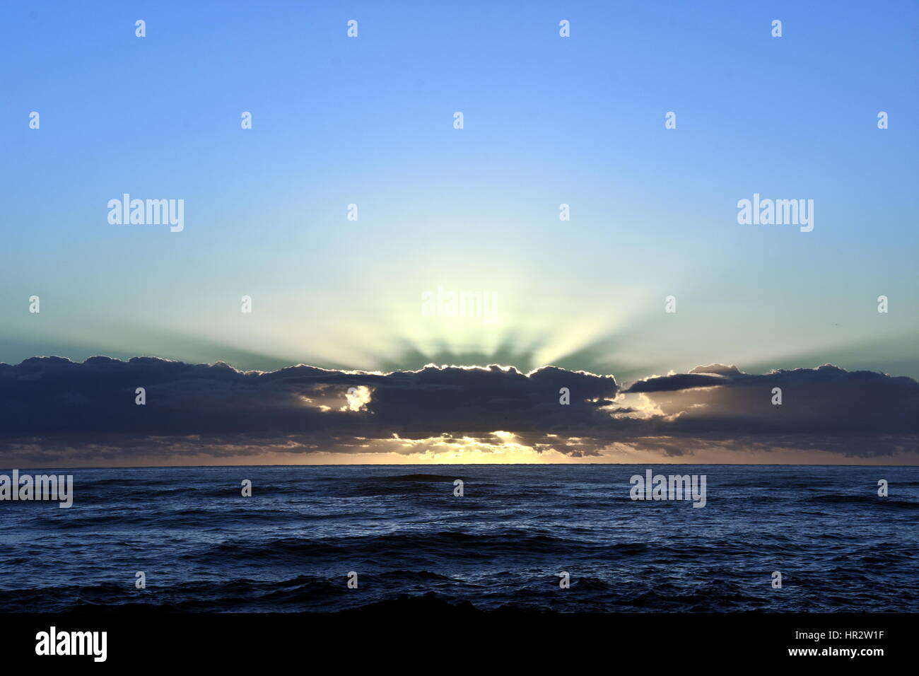 Beautiful sunrise cloudscape over ocean background. Sun rays beaming ...