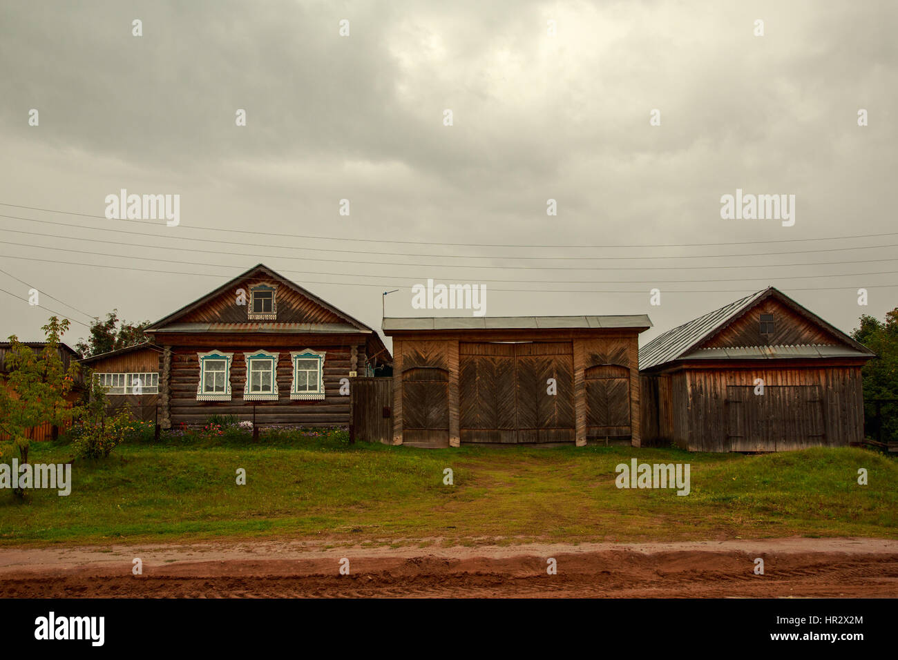 Ordinary wooden Russian log hut with a gate in a simple village on the ...