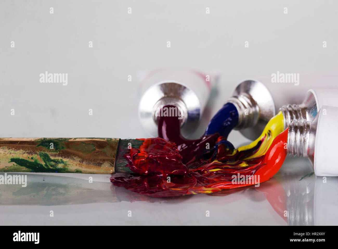 Open tubes with coloured paint squirting out Stock Photo - Alamy