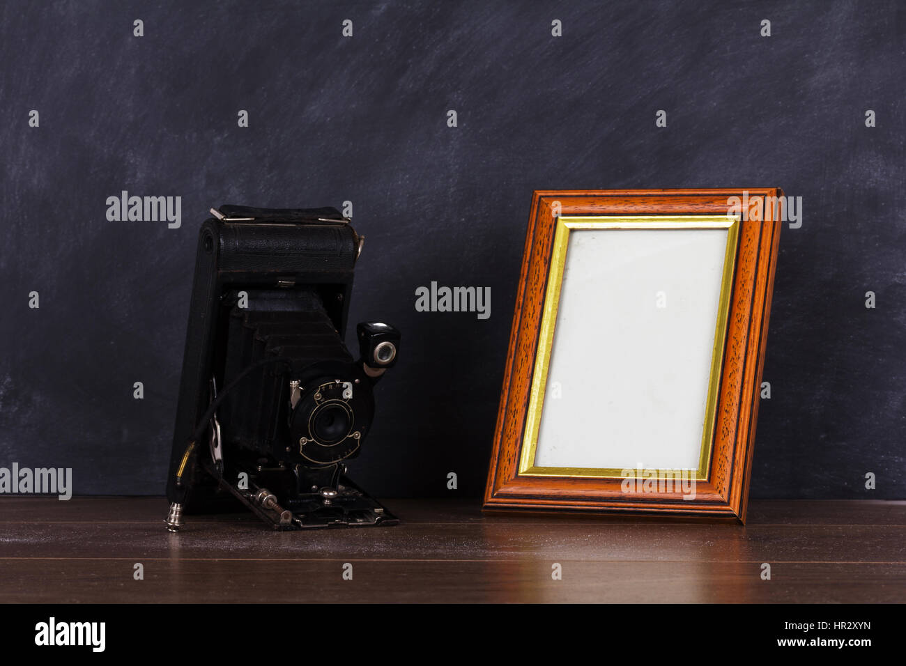 Old vintage camera and frame against blackboard background Stock Photo ...