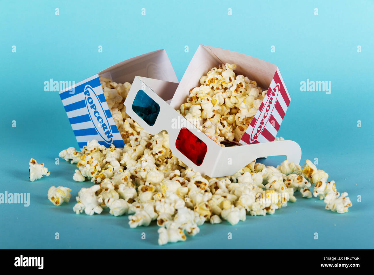 Bucket of popcorn against a blue background Stock Photo - Alamy