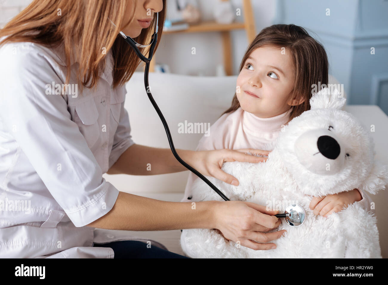 Involved in work. Nice professional female doctor using stethoscope and ...