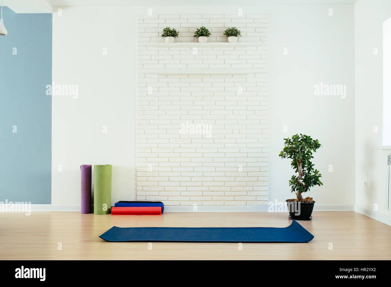 Yoga room with mat and white brick wall Stock Photo - Alamy