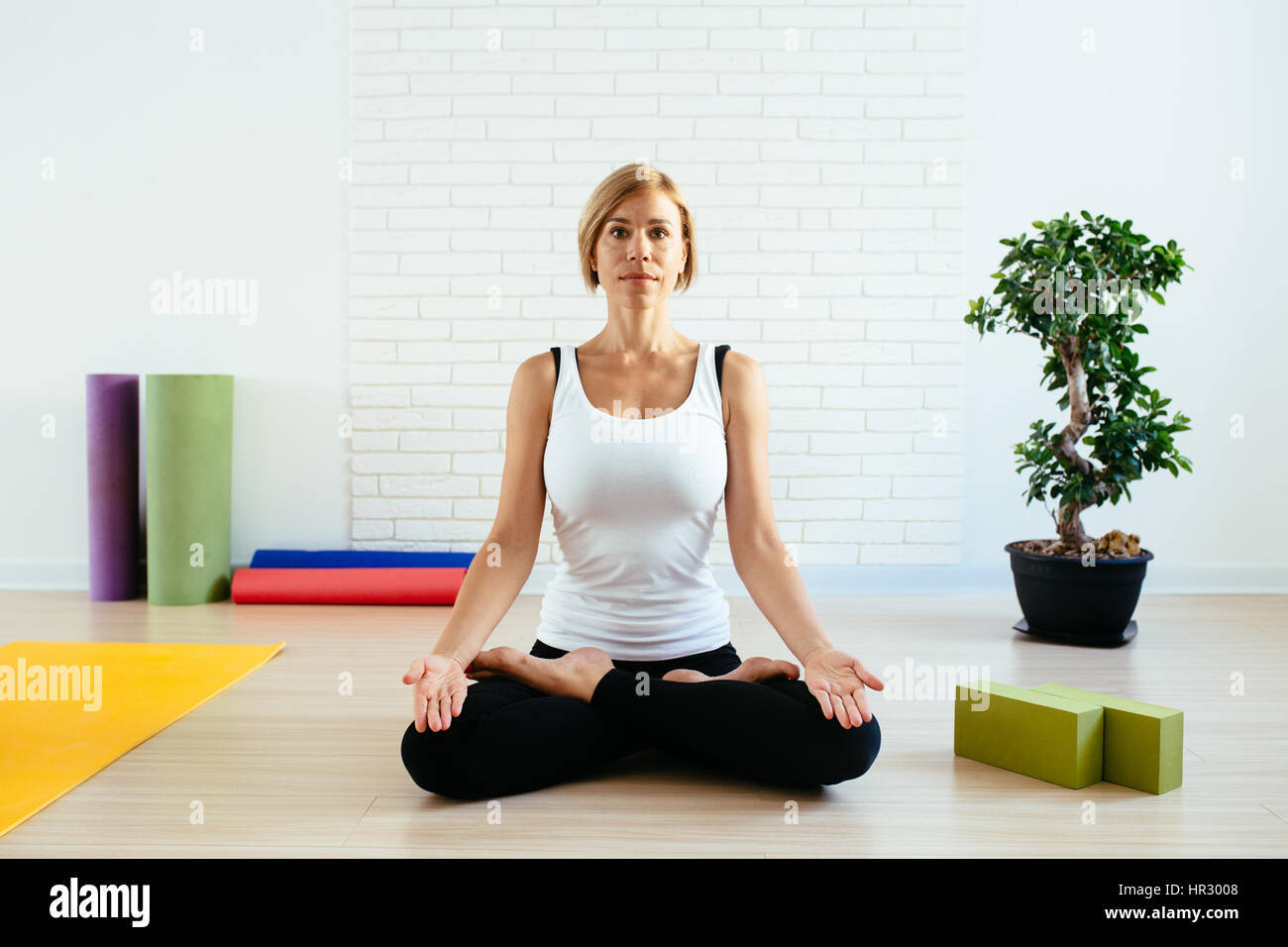 woman doing yoga in studio lotus position Stock Photo - Alamy
