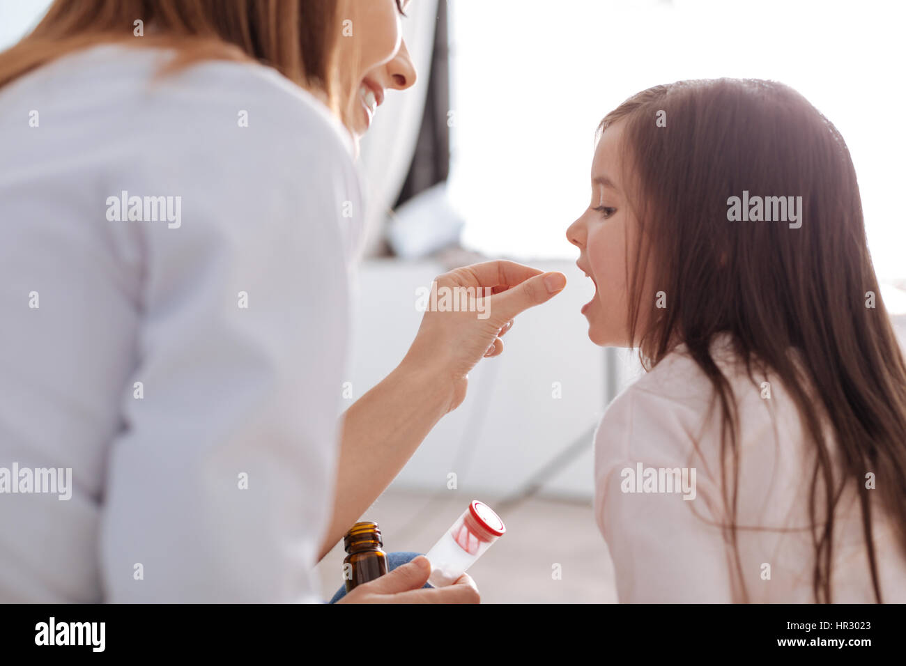 Daily take. Cheerful professional doctor smiling and giving pills to ...