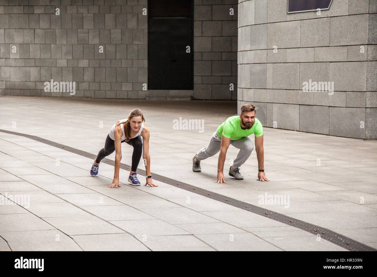 Young sport couple in starting position prepared to compete and run ...
