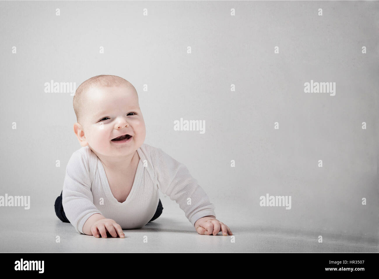 Smiling baby lying on the floor on white background Stock Photo - Alamy