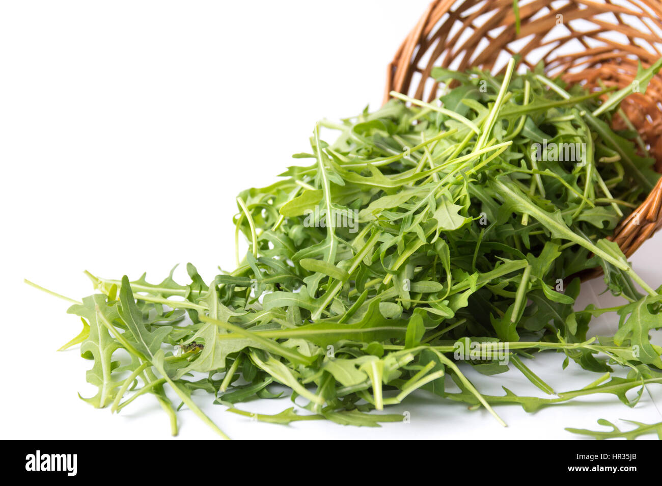 Rucola plant in a wicker bowl isolated Stock Photo - Alamy