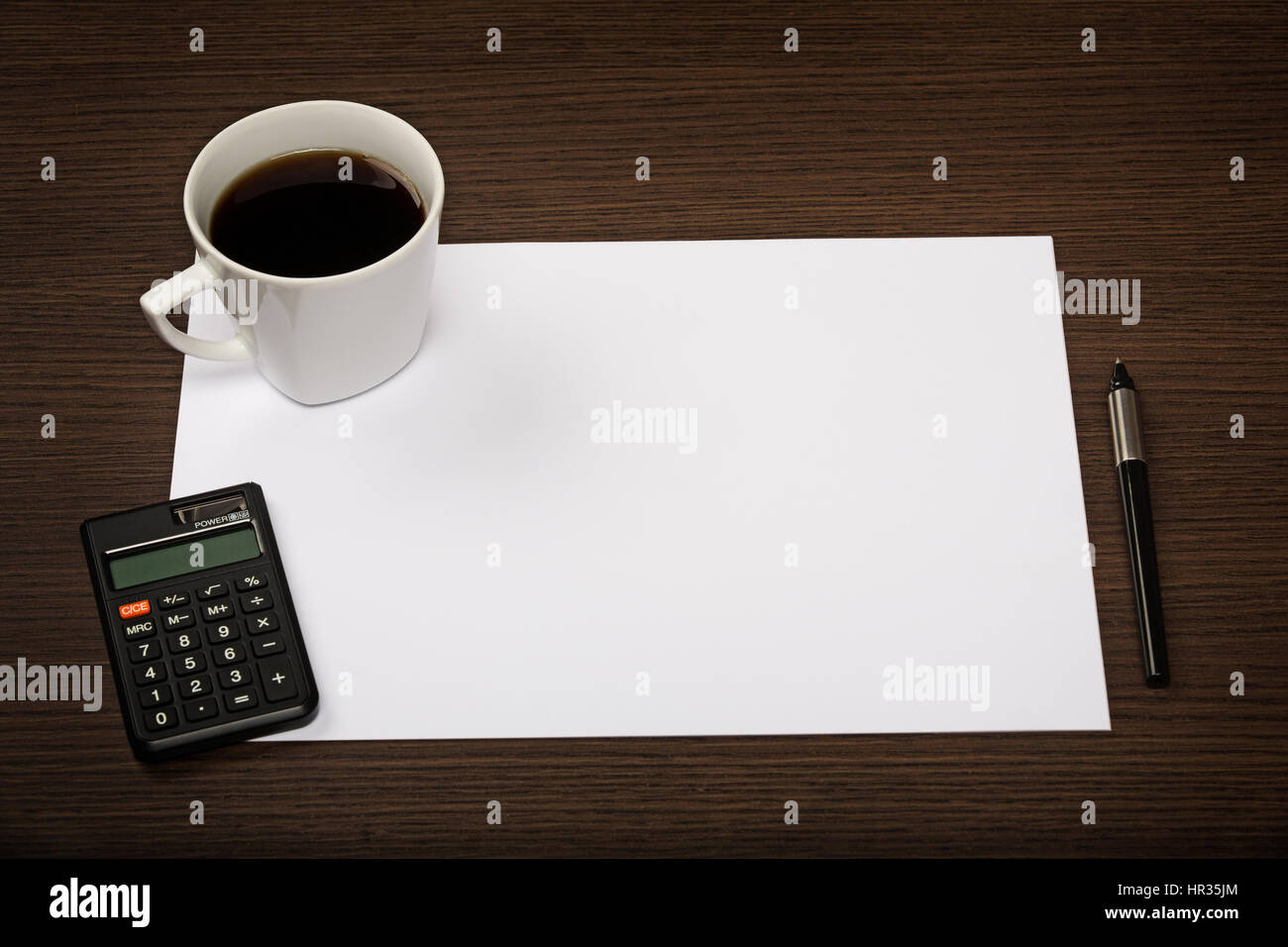 Blank sheet of paper, calculator, pen and cup of coffee on dark office ...
