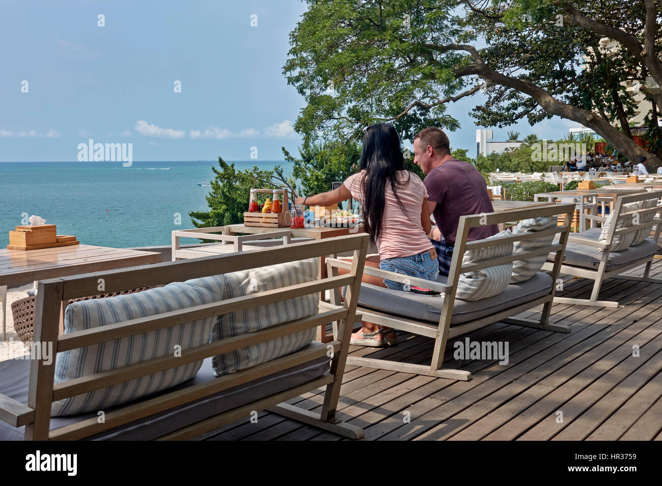 Couple dining on a restaurant balcony and terrace overlooking the sea ...