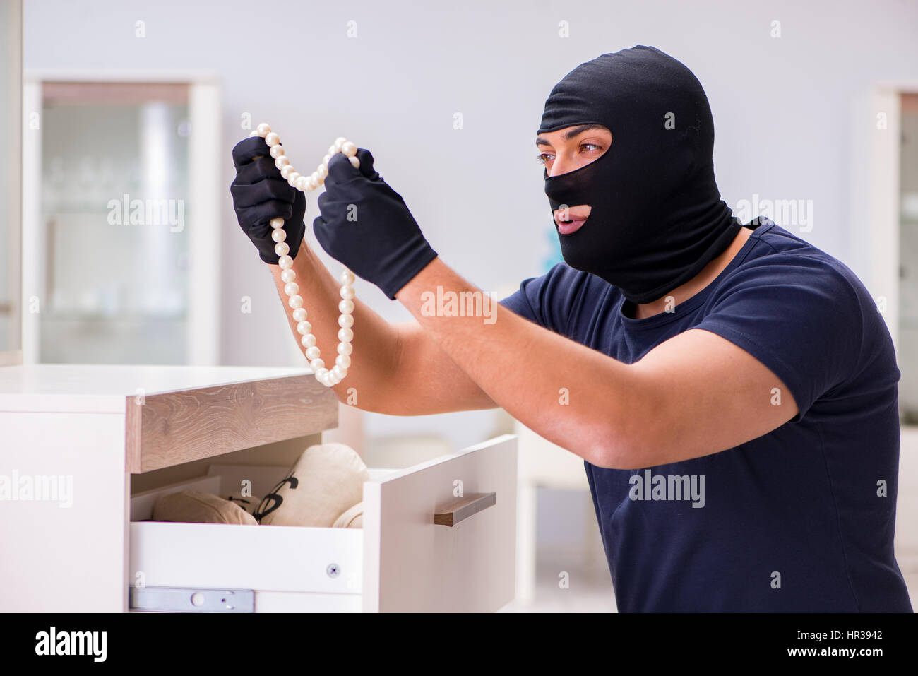 Robber wearing balaclava stealing valuable things Stock Photo - Alamy