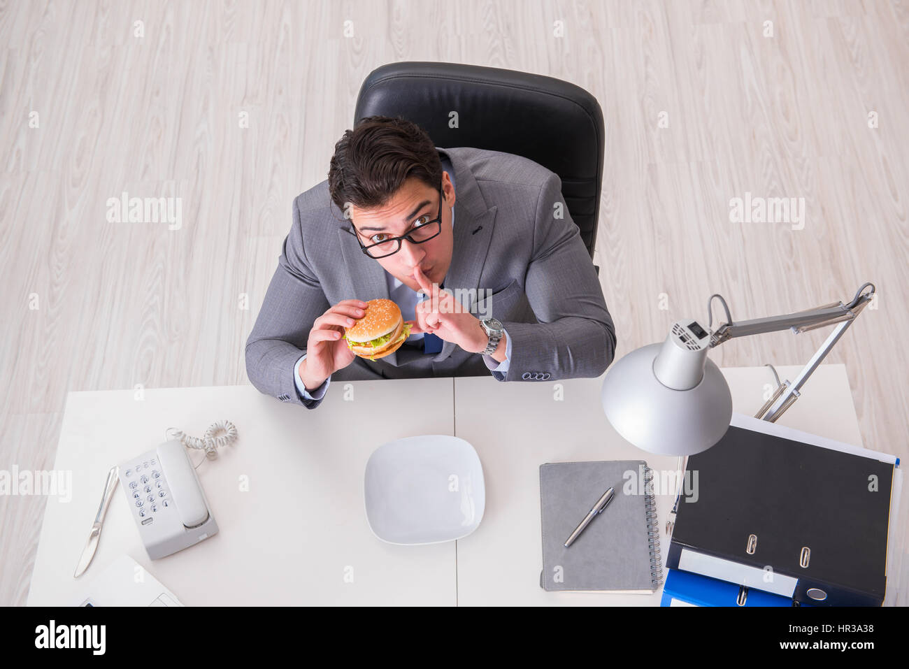 Hungry funny businessman eating junk food sandwich Stock Photo - Alamy