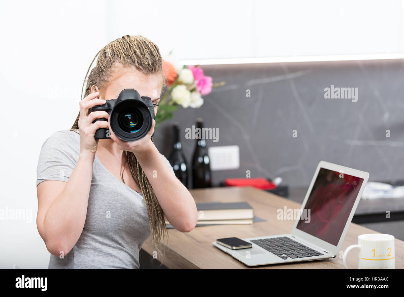 passionate woman is a photographer in her kitchen, with her faithful ...