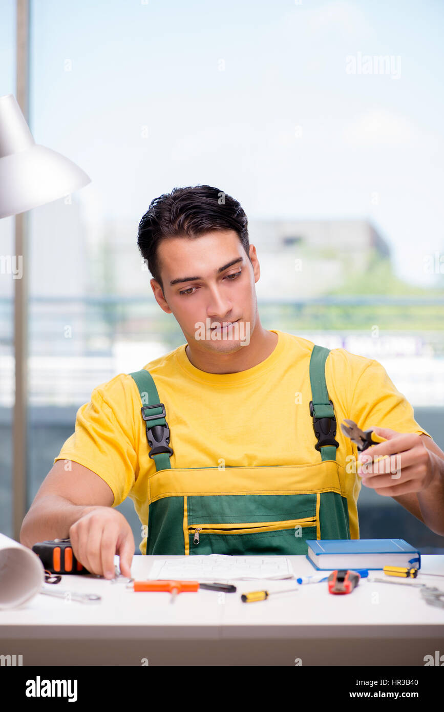 Construction worker sitting at the desk Stock Photo - Alamy