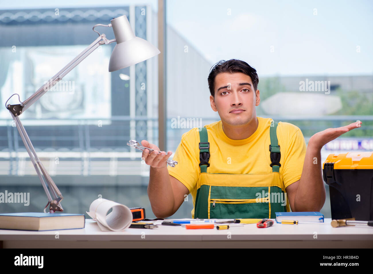 Construction worker sitting at the desk Stock Photo - Alamy