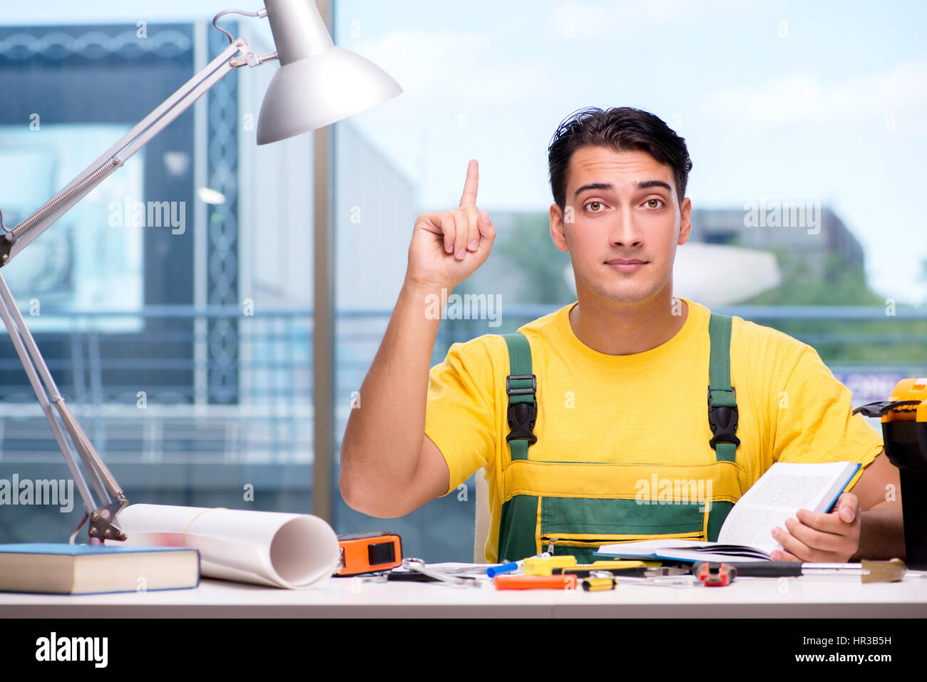 Construction worker sitting at the desk Stock Photo - Alamy