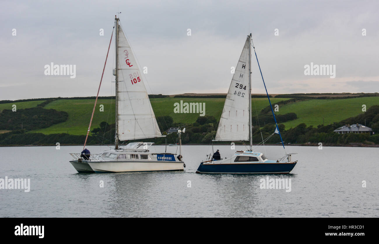 Two catamarans raising sails on a summers morning after a calm night at ...