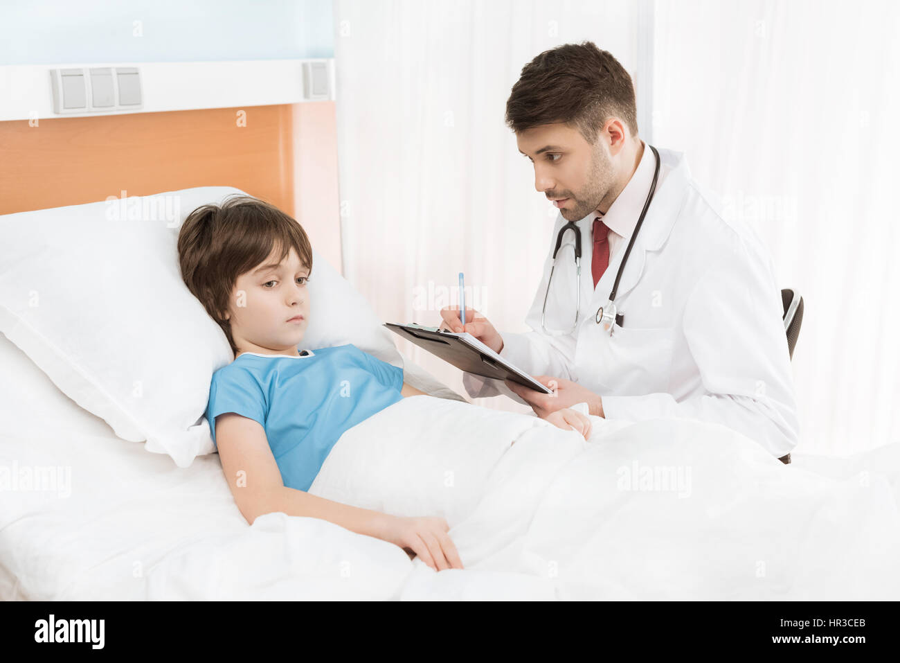 doctor writing down child patience's symptoms in hospital Stock Photo ...