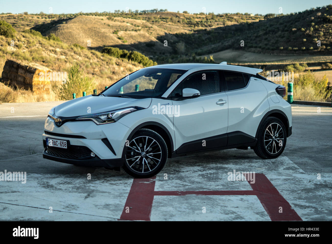 Front angle of a white Toyota C-HR CHR on a helipad, hills and scenery ...