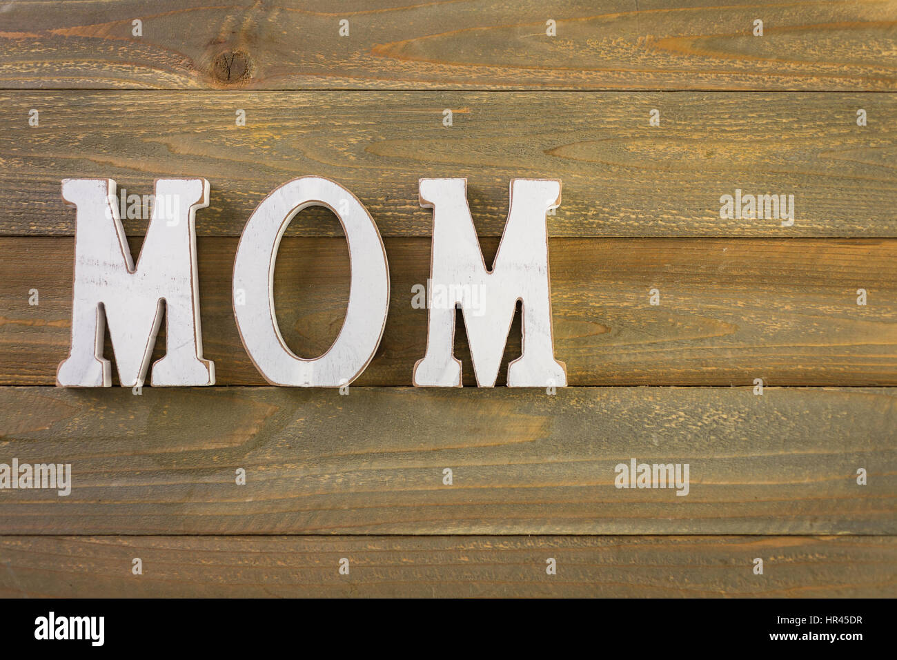 White letters MOM on a painted wood background Stock Photo - Alamy